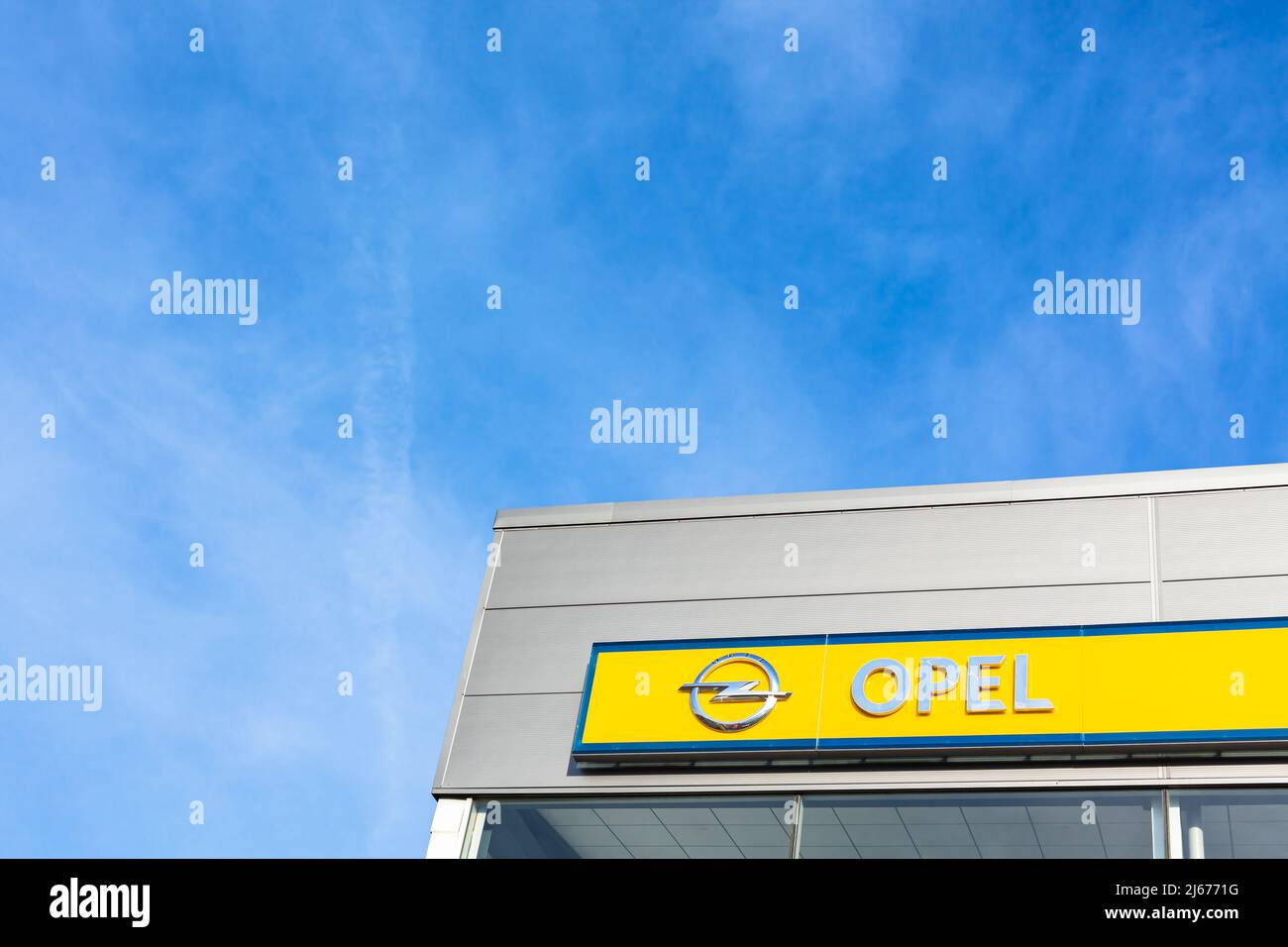 Opel brand logo on bright blue sky background located on its dealer ...