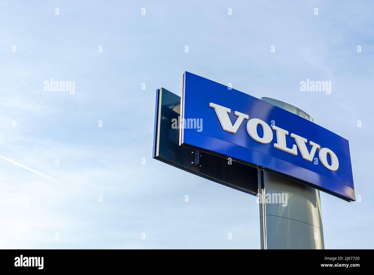 Volvo brand logo on bright blue sky background located on its sale ...