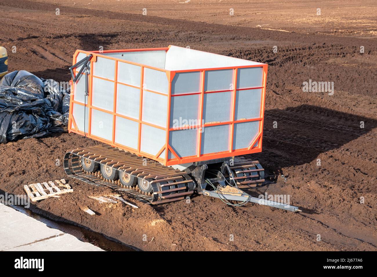 a tractor trailer in a swamp for the collection and removal of peat ...