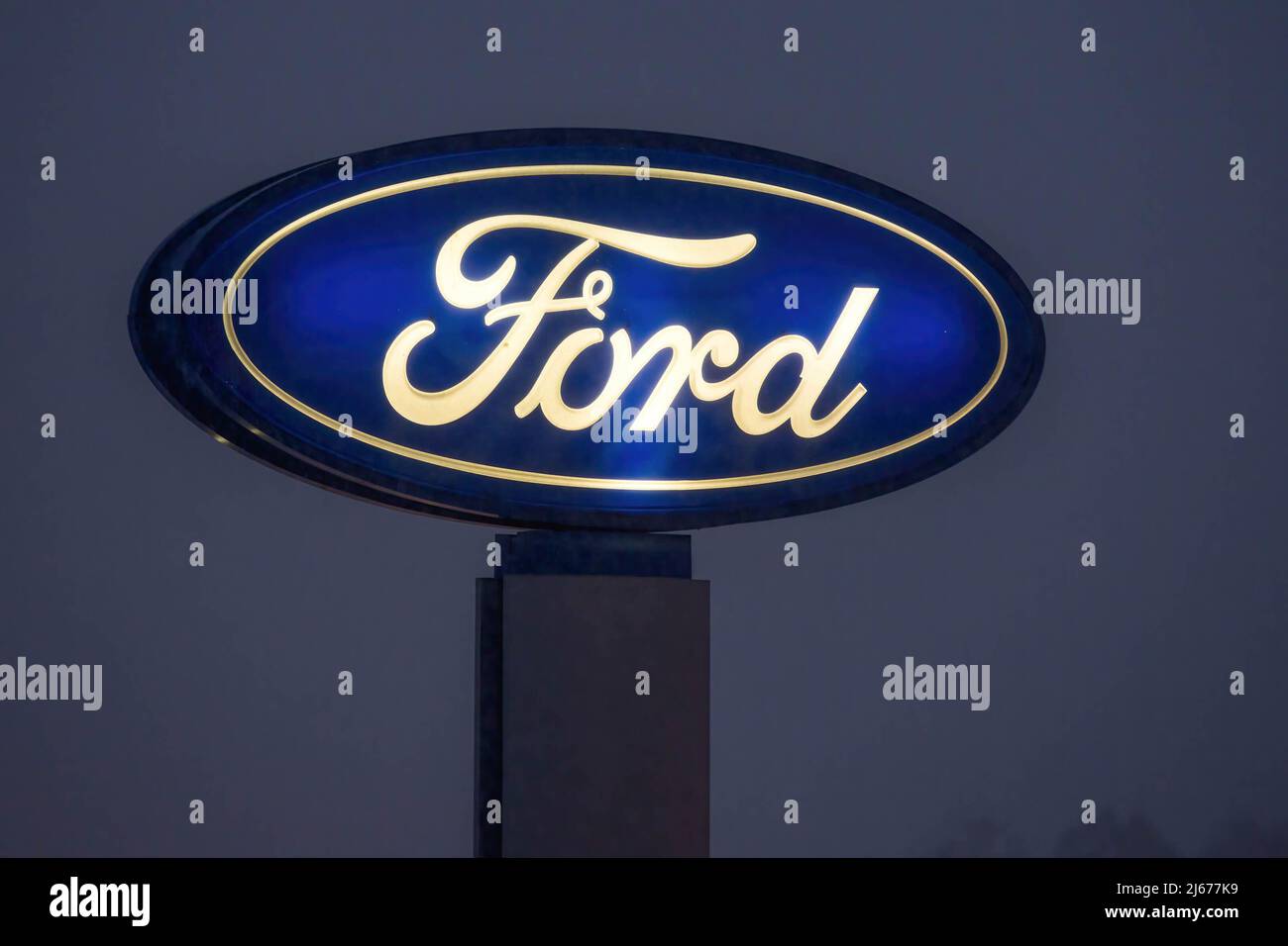 A view of an illuminated signboard with the Ford logo. (Photo by Karol ...