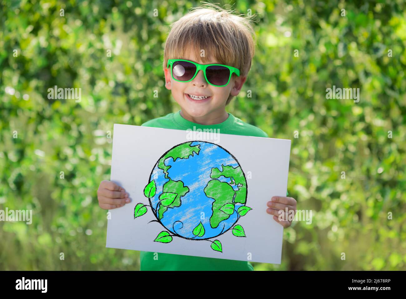Happy child showing white paper blank. Portrait of kid outdoor. Boy ...