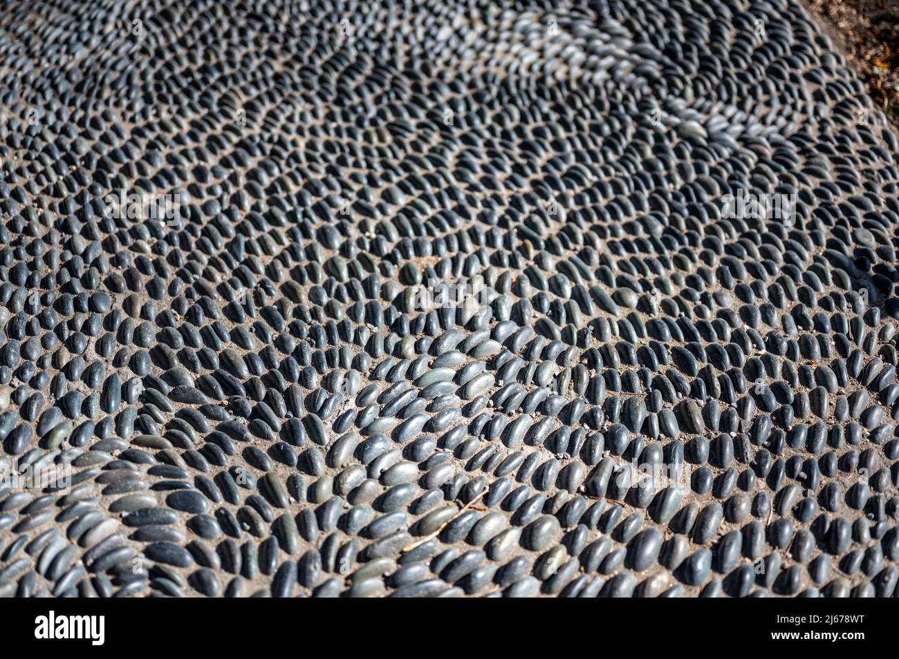 Selective focus on decorative pattern of river rocks laid in garden ...