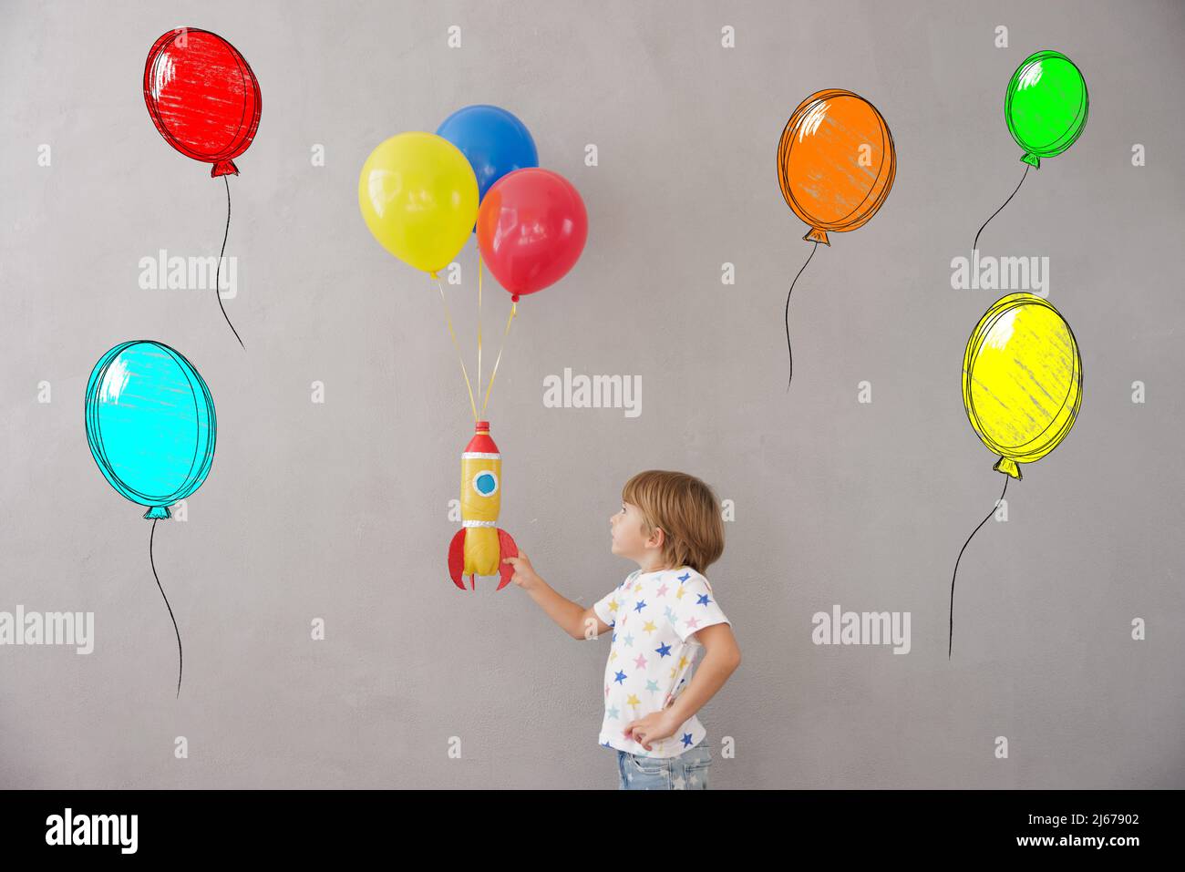 Happy child playing with toy rocket at home. Kid pretend to be ...