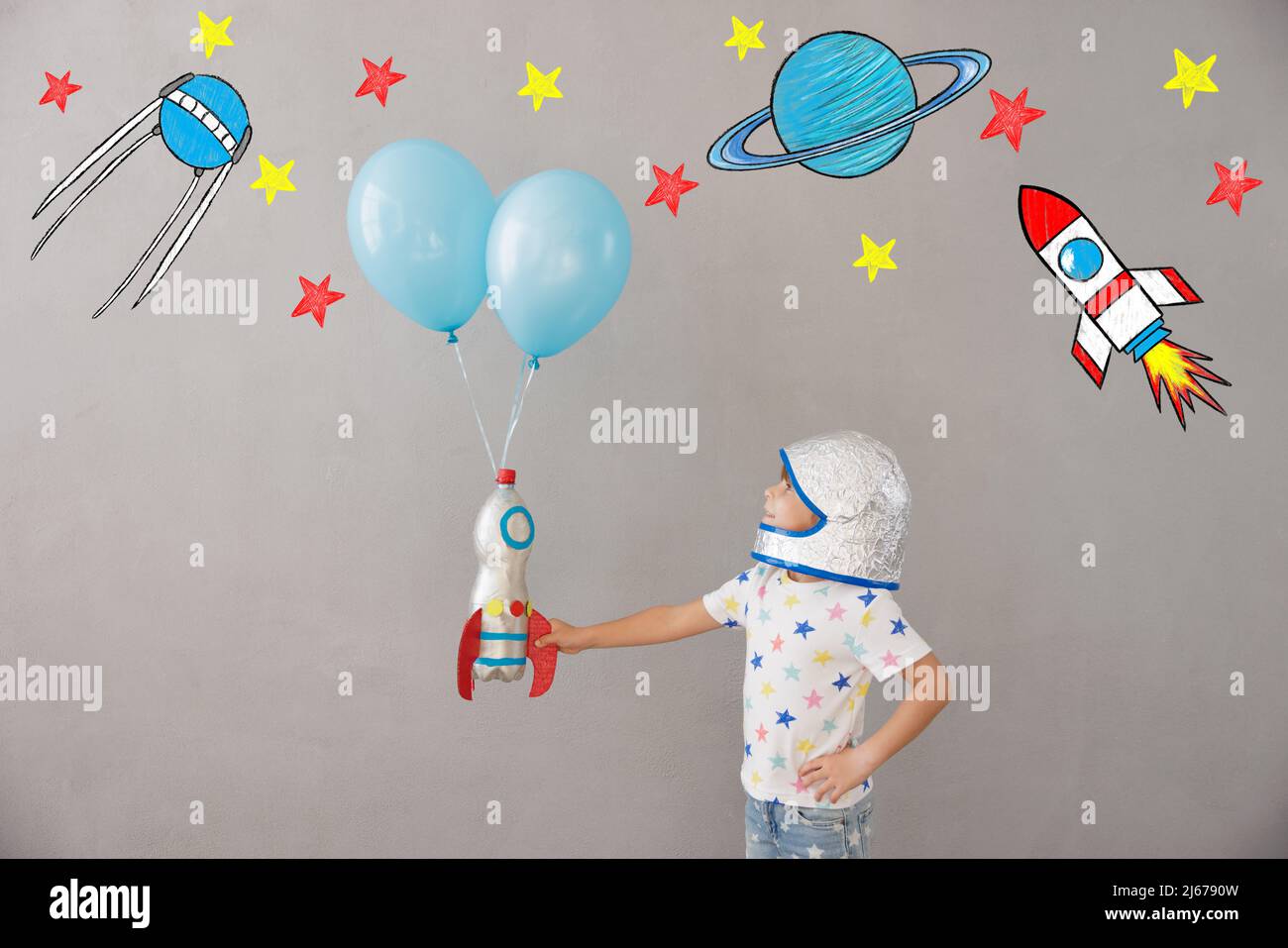 Happy child playing with toy rocket at home. Kid pretend to be ...
