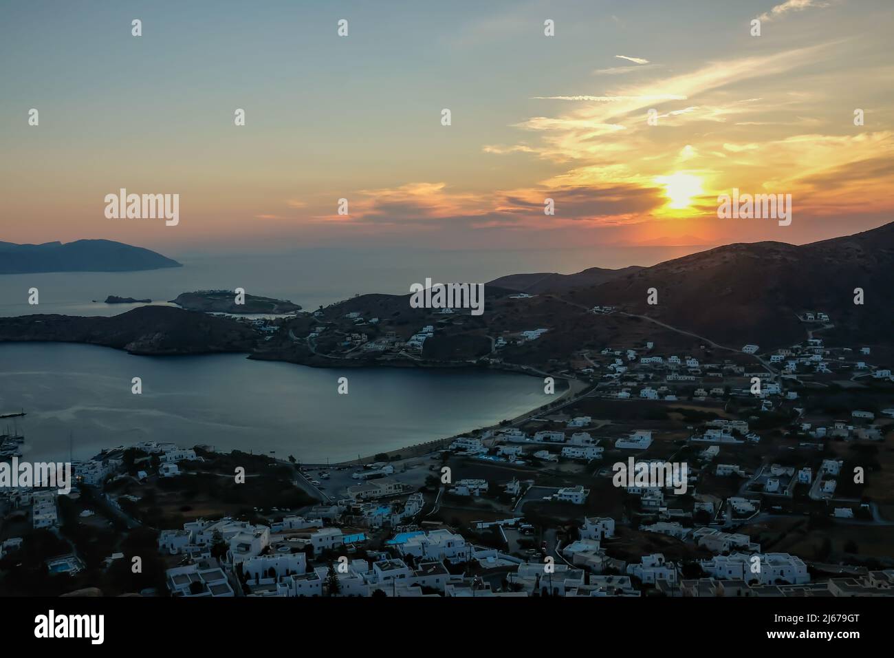 Colorful sunset and view of the illuminated harbor of Ios and the ...