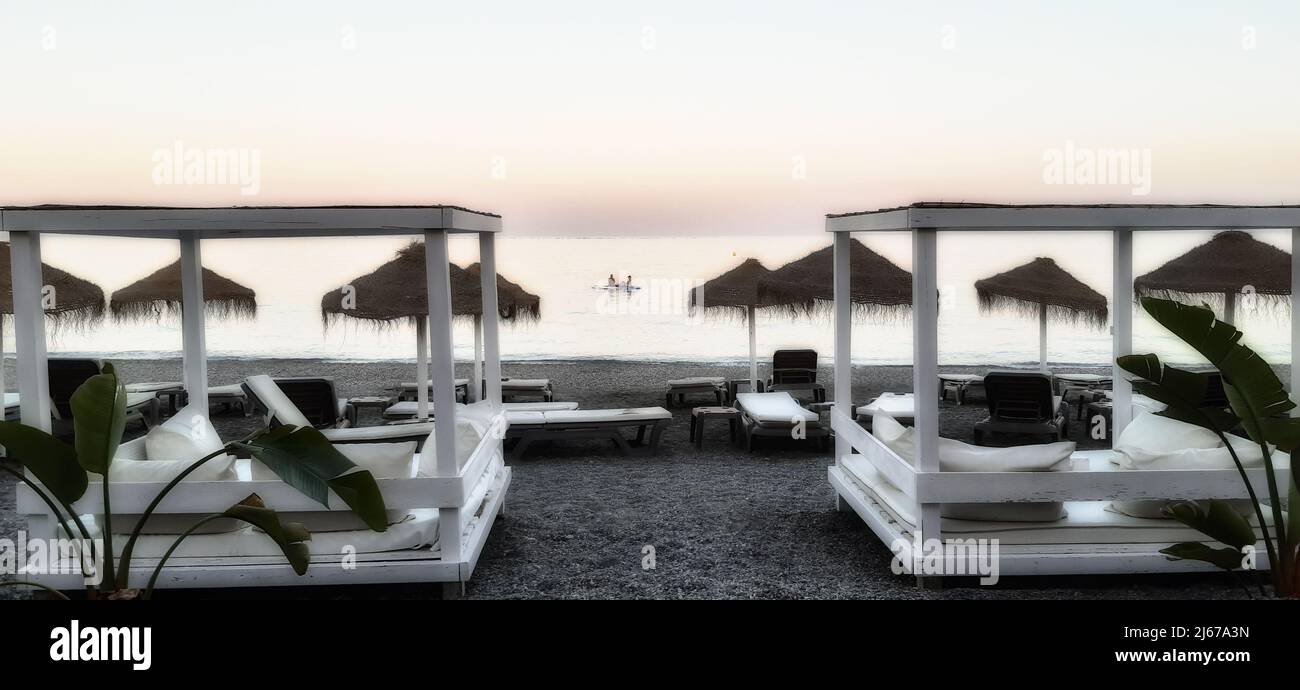 Beach umbrellas and sunbeds without tourists at sunset Stock Photo - Alamy