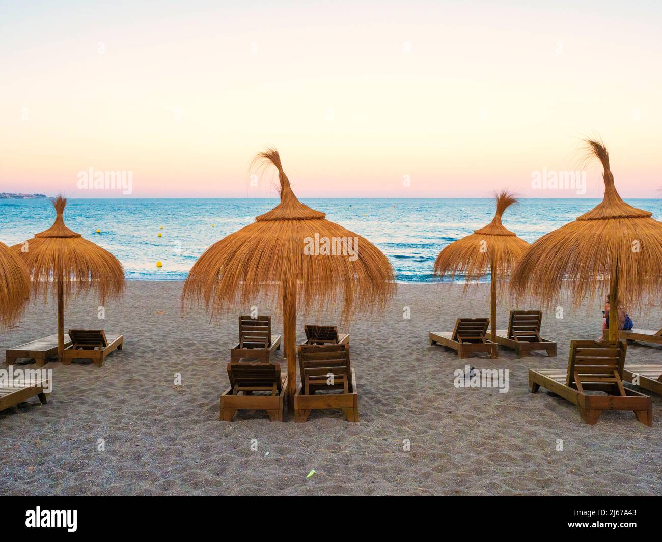 Beach umbrellas and sunbeds without tourists at sunset Stock Photo - Alamy