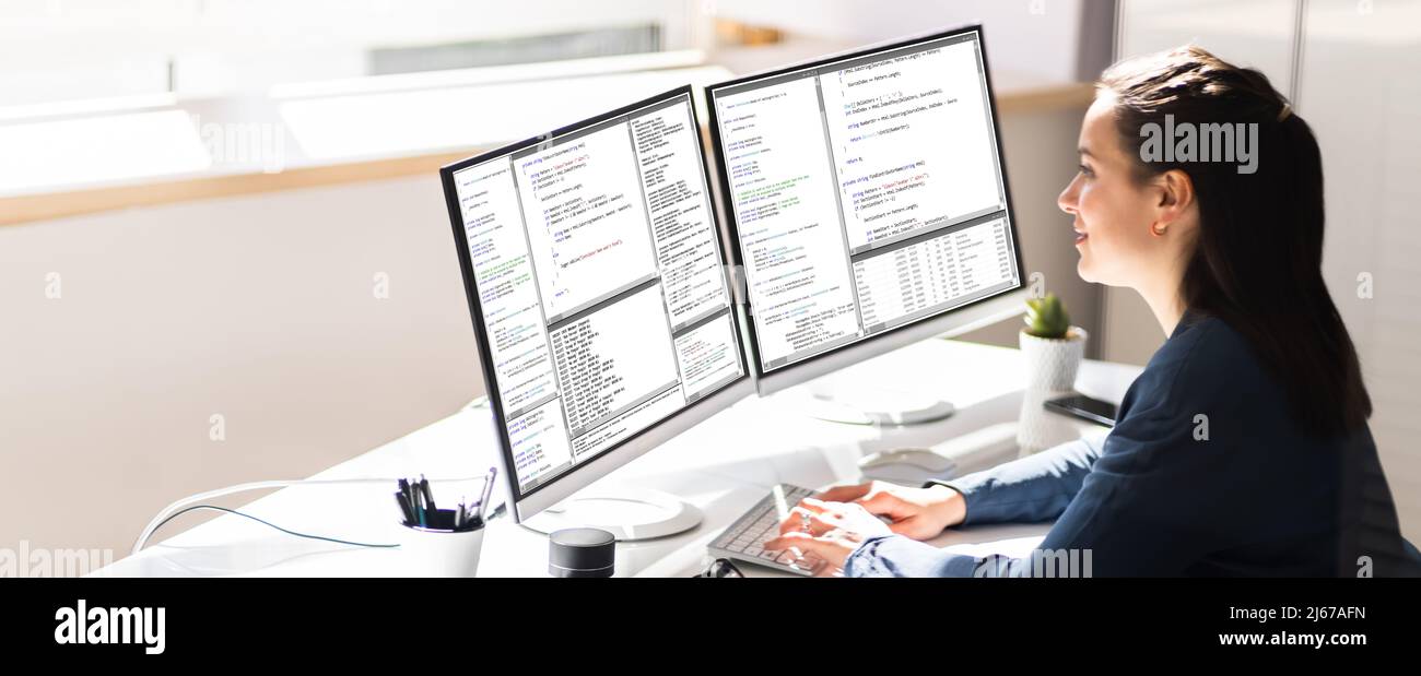 Coder Engineer Using Multiple Monitors At Desk Stock Photo - Alamy