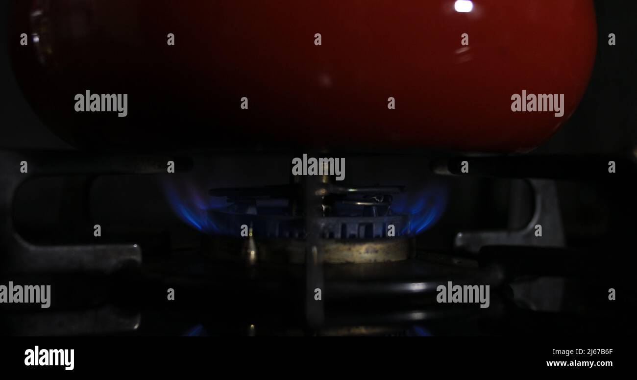 Ignition of the heat under the red pot in the kitchen Stock Photo - Alamy