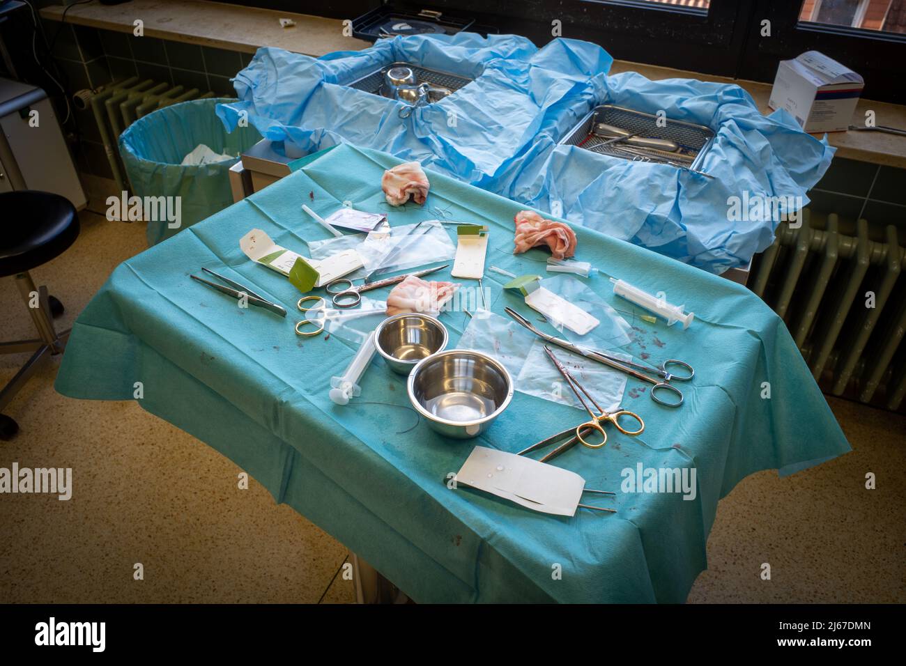 in an operating room there is a used operating table with instruments ...