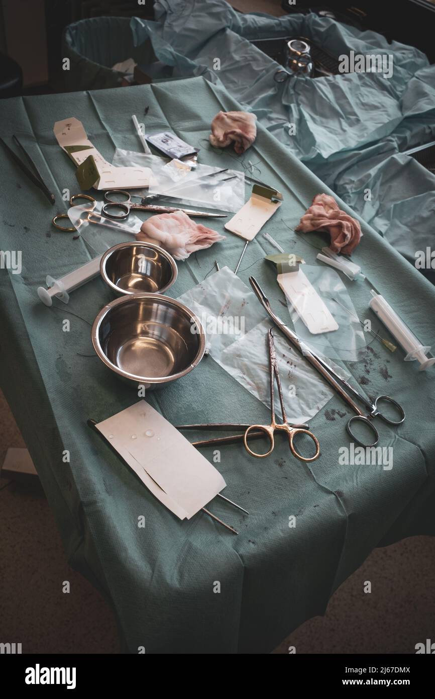 in an operating room there is a used operating table with instruments ...