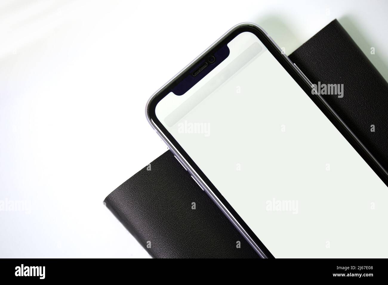 smartphone with black leather notebook on white background Stock Photo ...