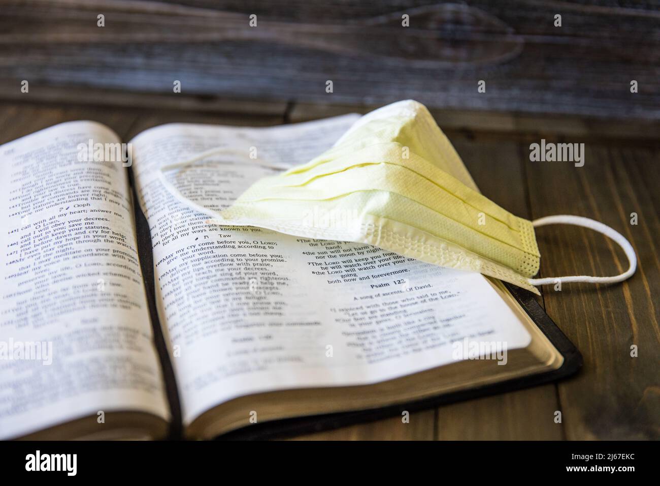 Surgical mask laying on an open Bible, with scripture pointing to God ...