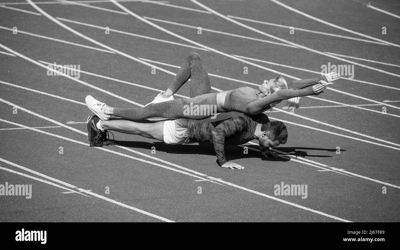 sport fitness man and woman training together stand in plank and do ...