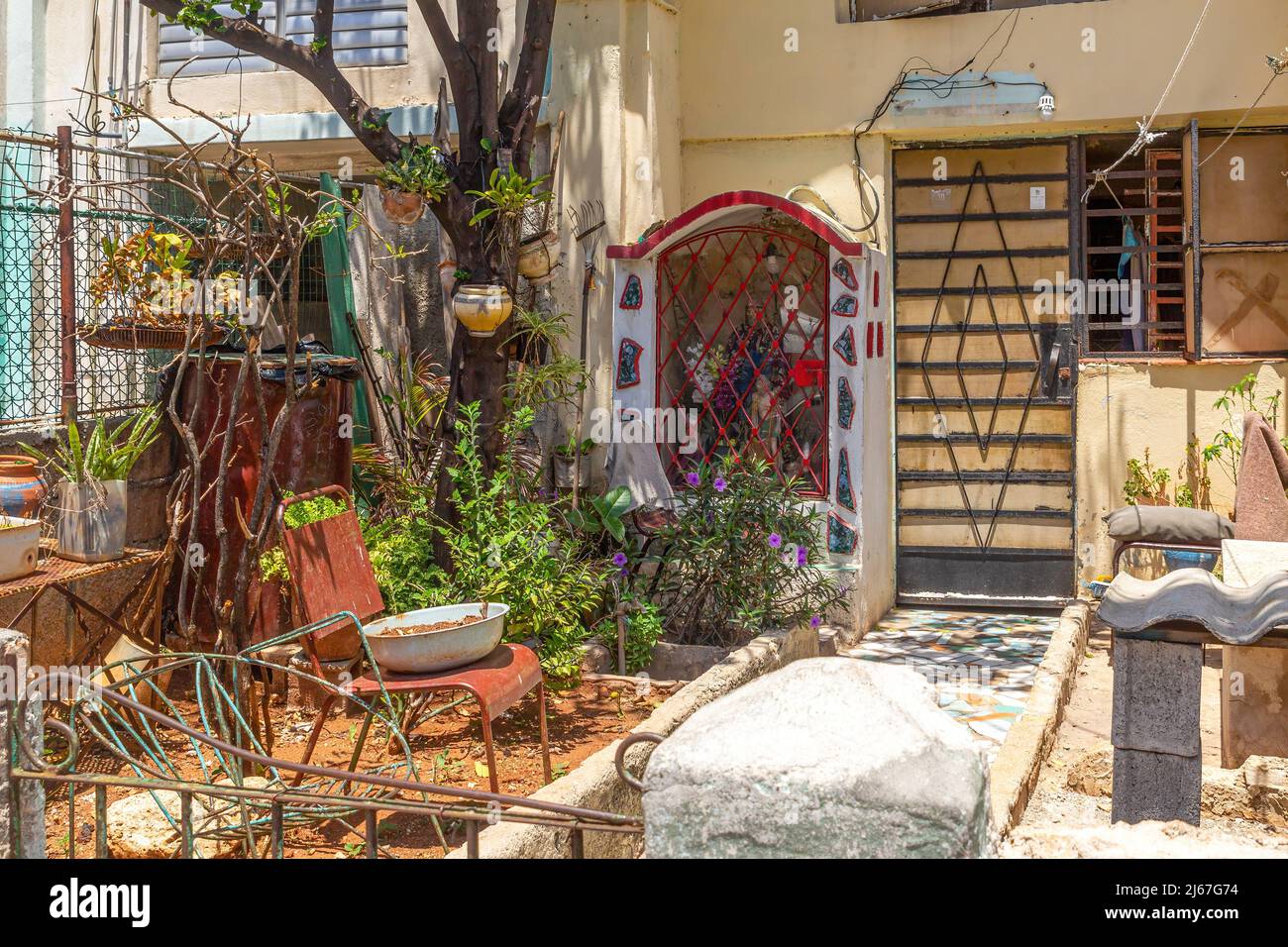 A statue of Saint Lazarus is behind a red metallic grid at the entrance ...