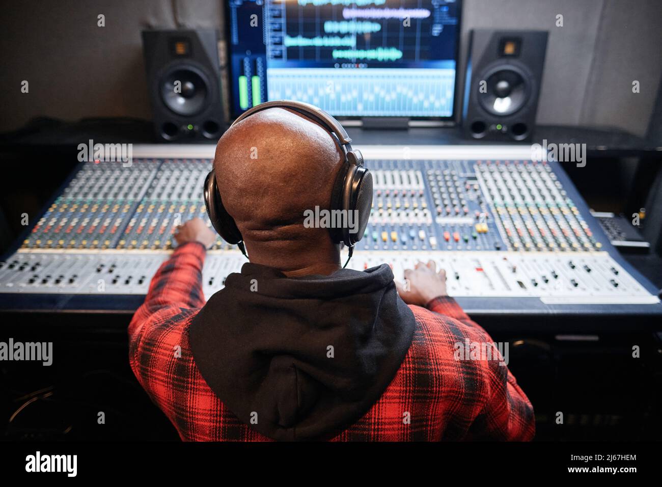 Rear view shot of unrecognizable Black sound engineer producing ...