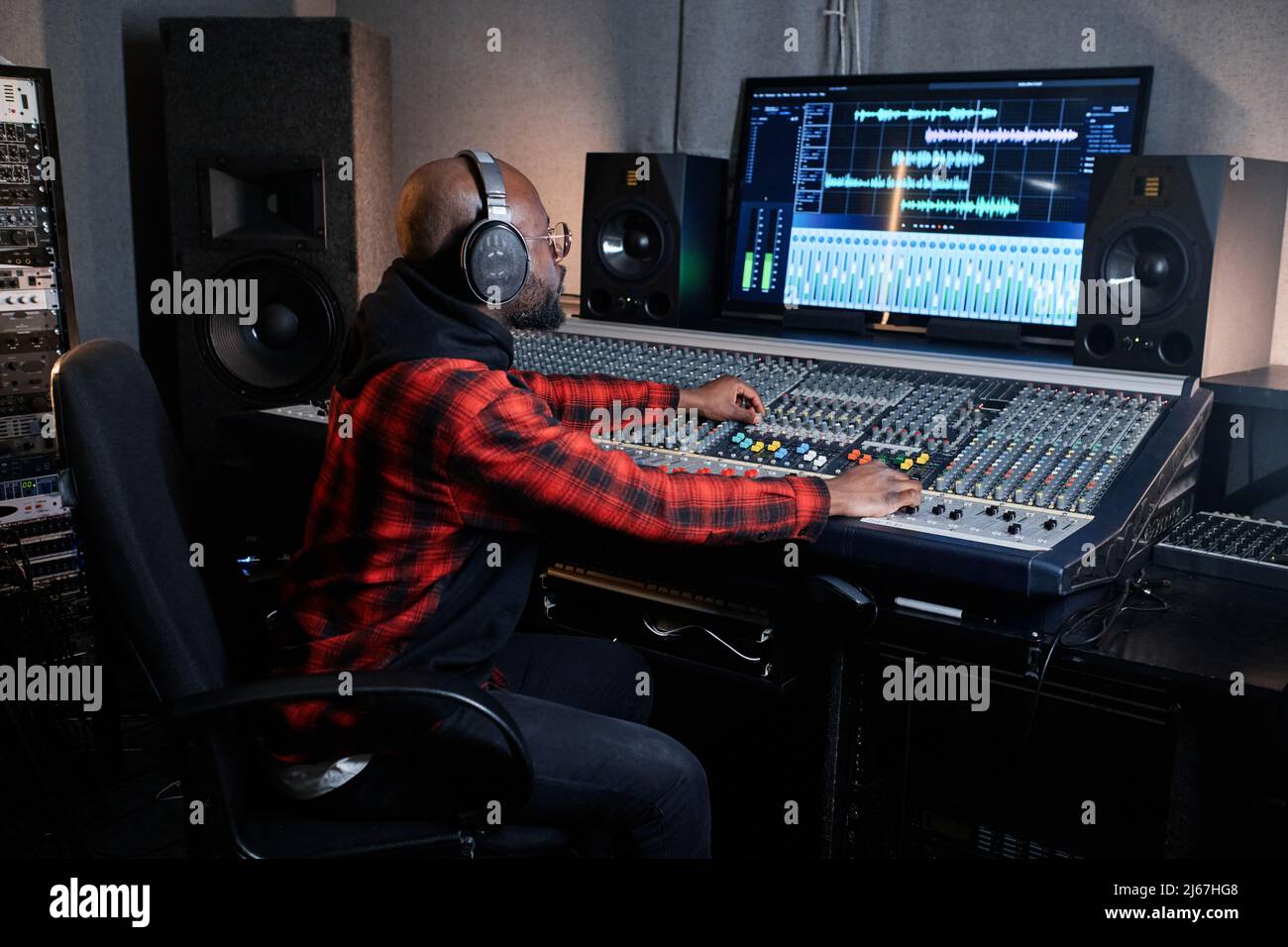 Professional African American recording producer wearing headphones ...