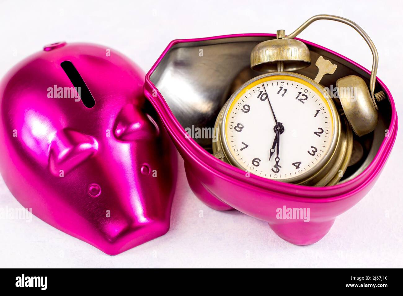 Pink piggy coin bank with retro clock inside on light background ...