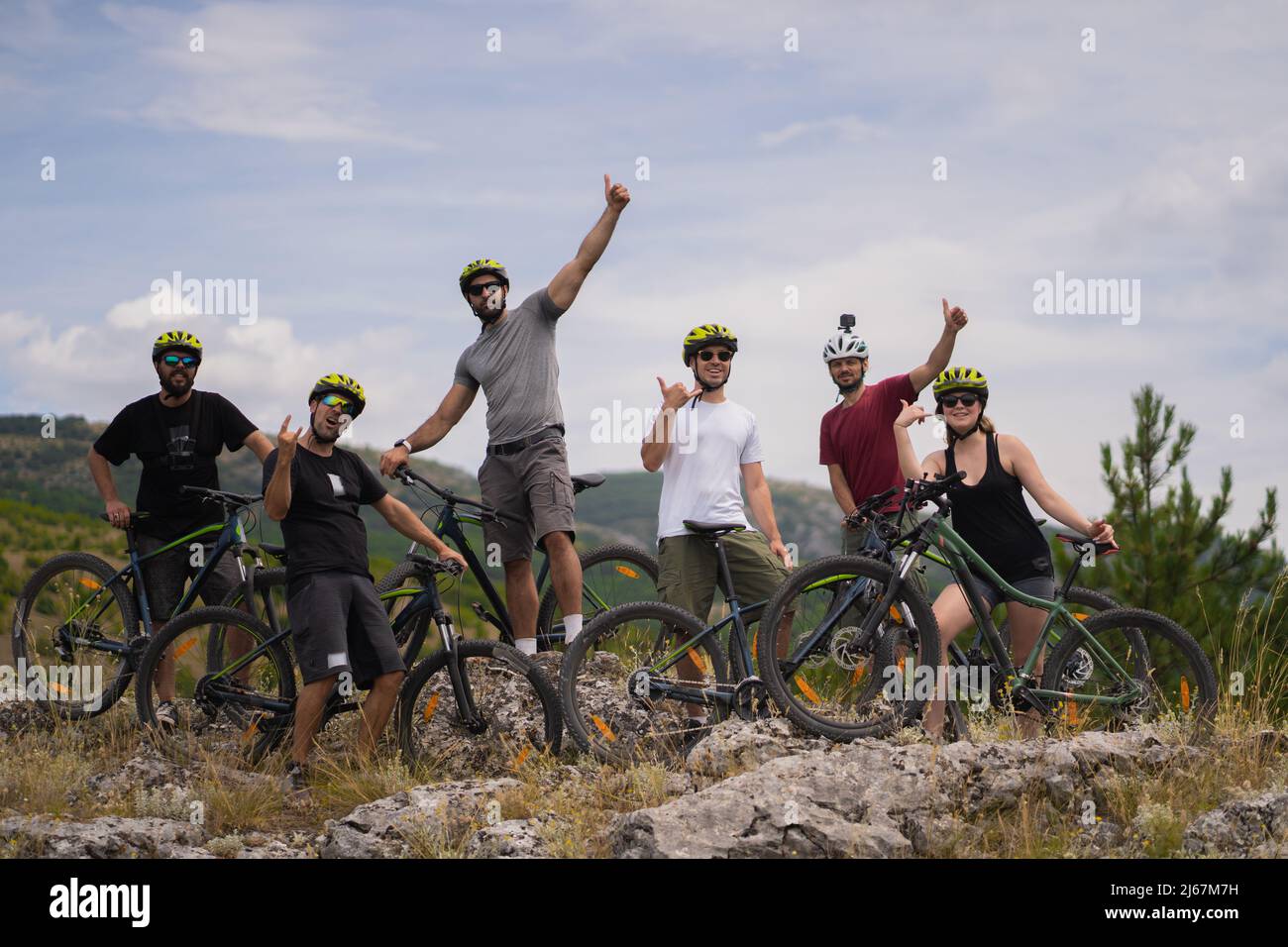 Group of happy friends with bikes are posing on topo of the hill Stock ...