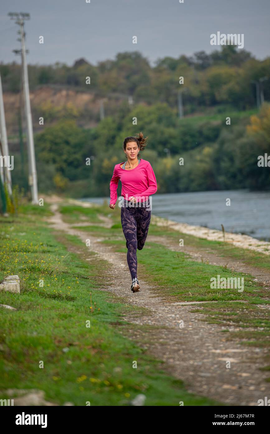Attractive and fit girl is running by her self in the morning, by the ...