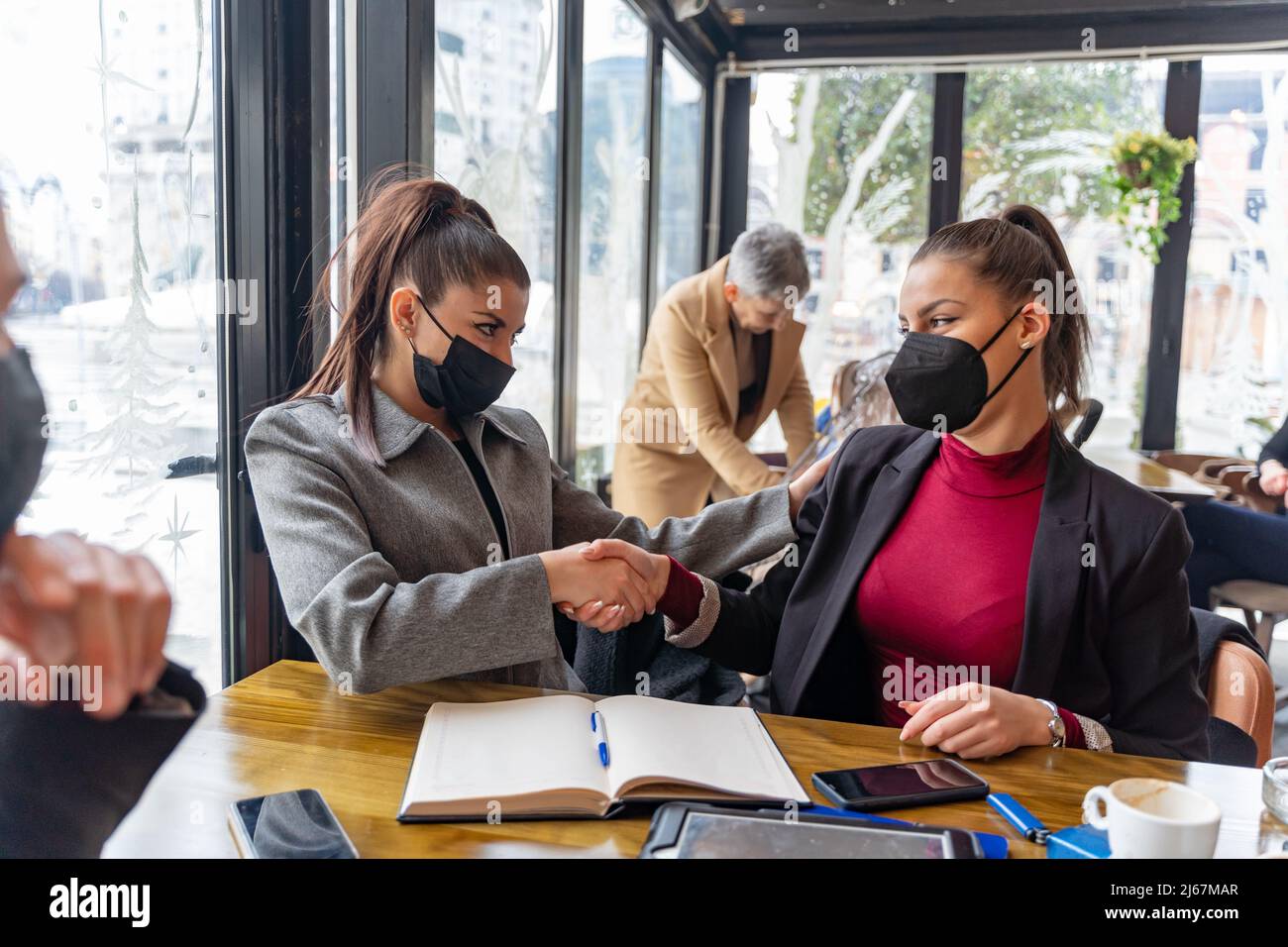 Two amazing and attractive business women are making a deal, covid ...