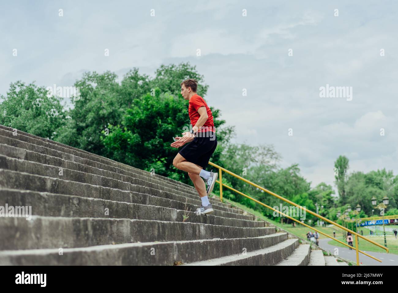 Fit male athlete performing stairs workout, running up climbing stairs ...