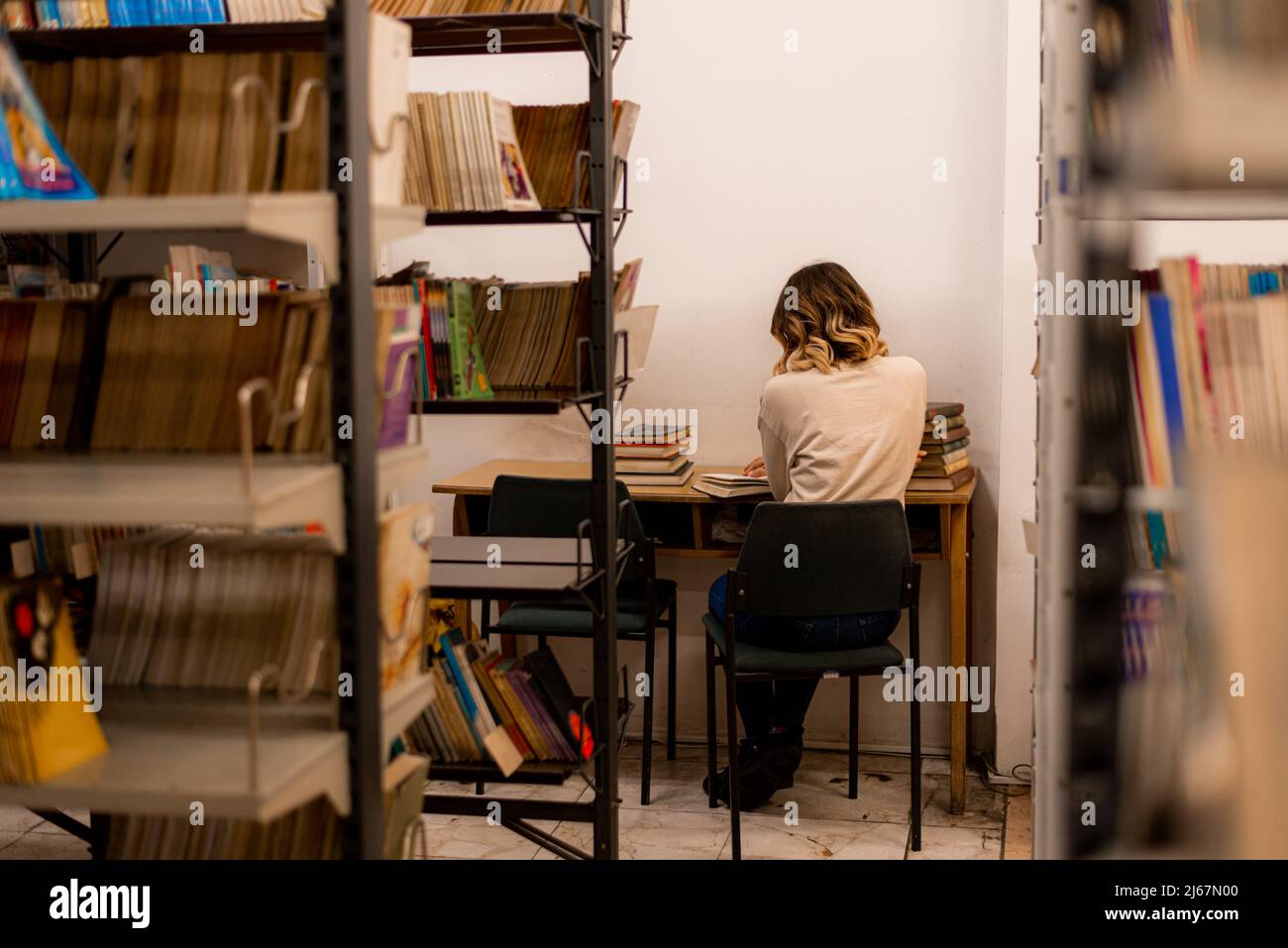 Girl reading for college on a desk in a library while sitting Stock ...