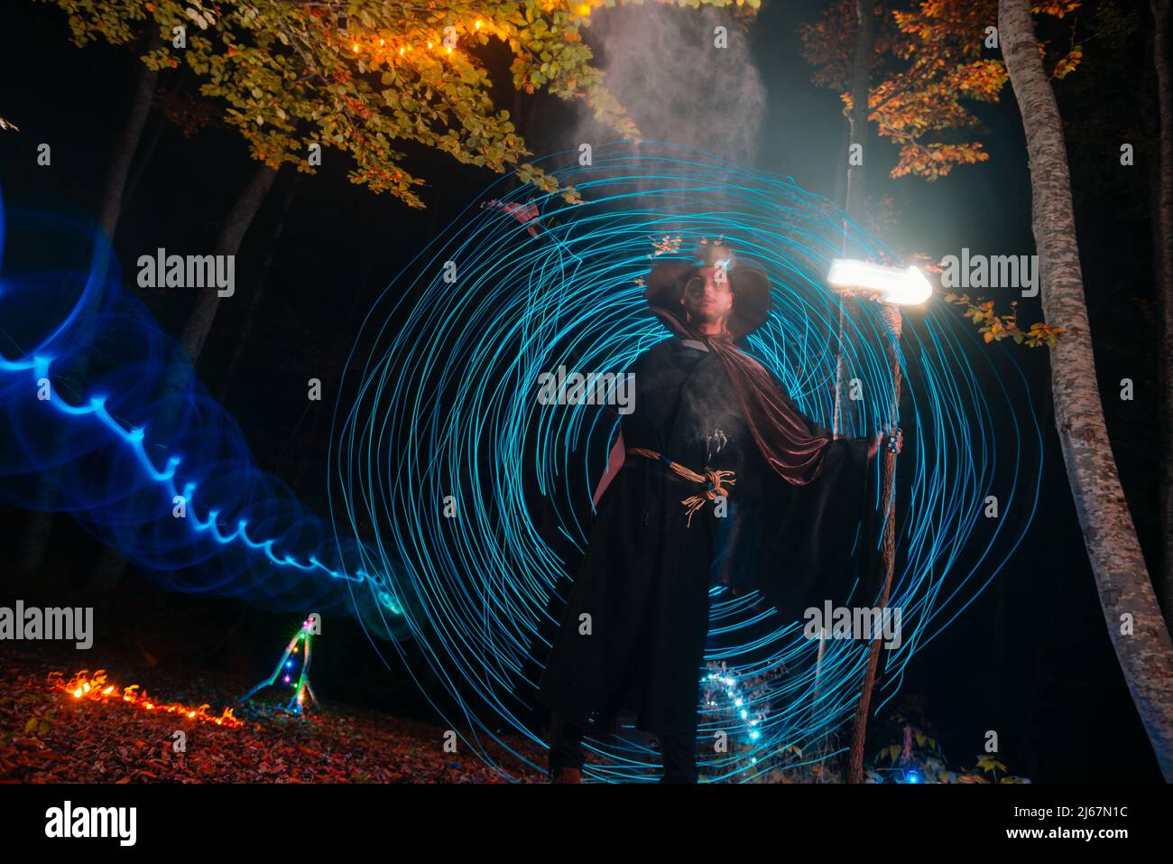 Sorcerer (magician) casting a spell while standing in the magical woods ...