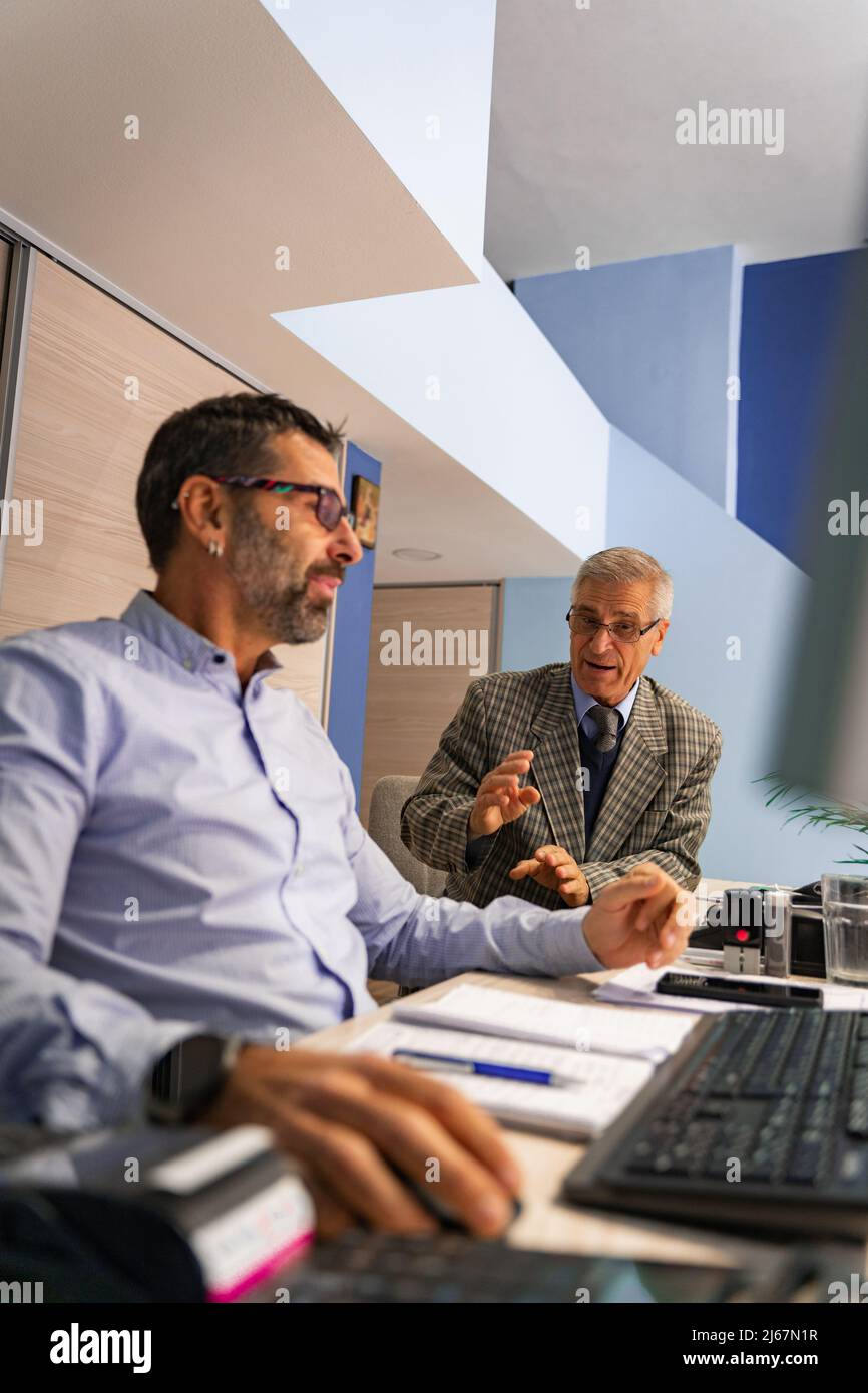 Two senior businessmen are having a discussion about the project for ...