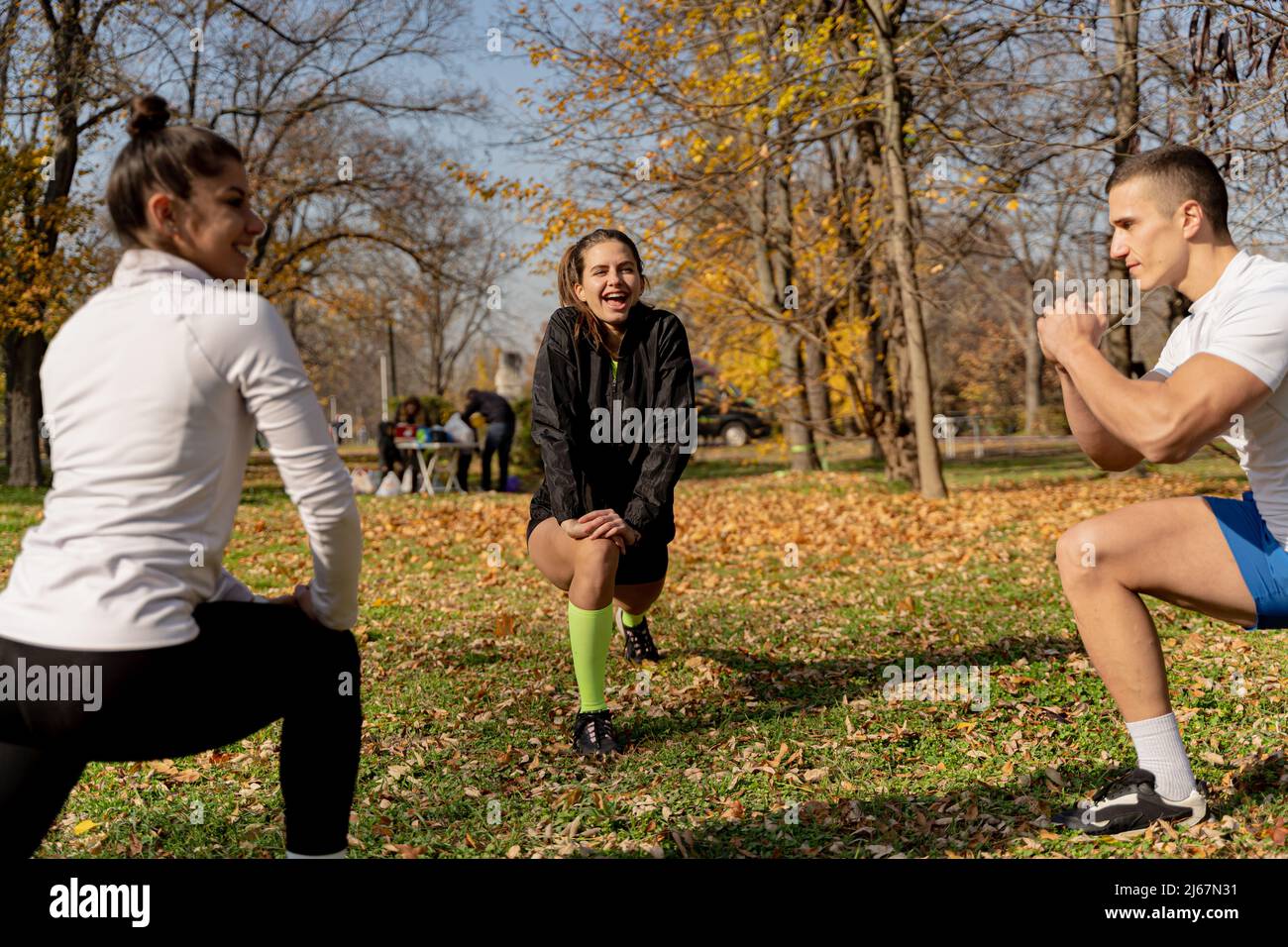 Three attractive and amazing fit friends are stretching and smiling ...