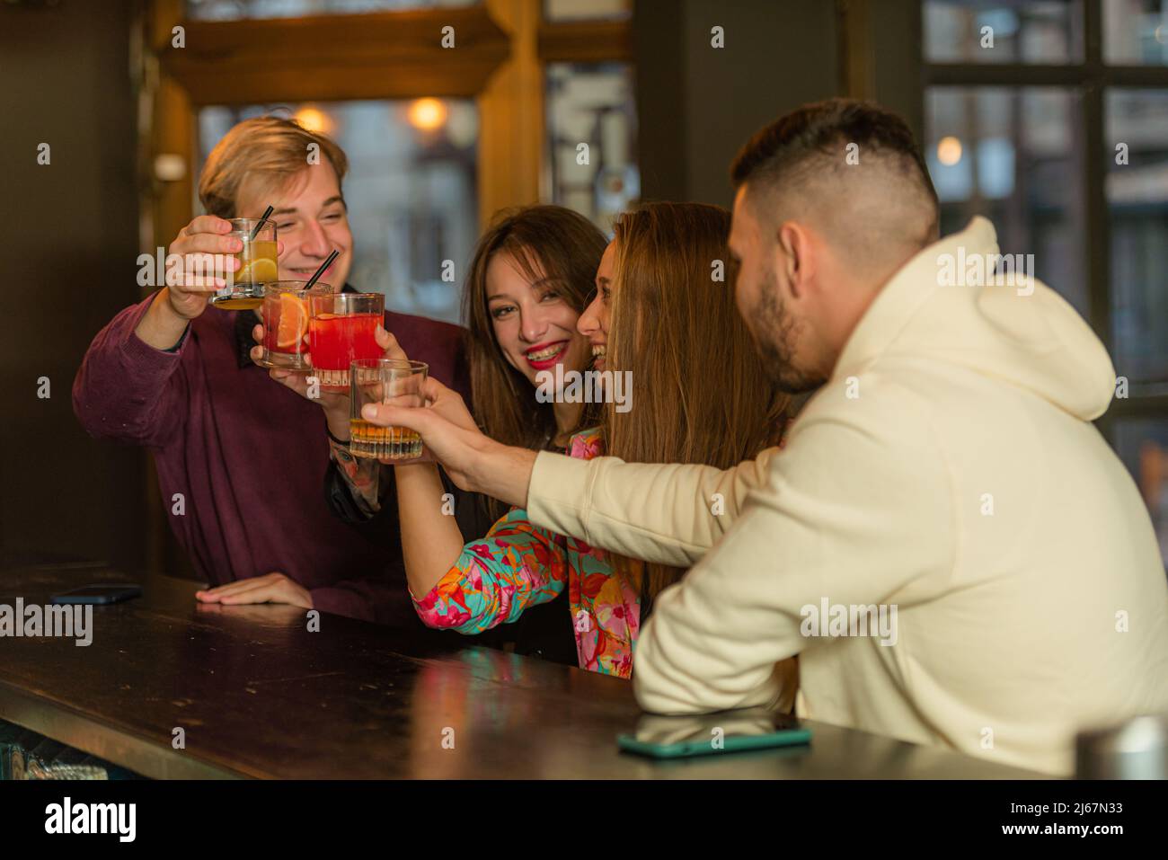 Two amazing and beautiful couples are doing cheers with their drinks ...