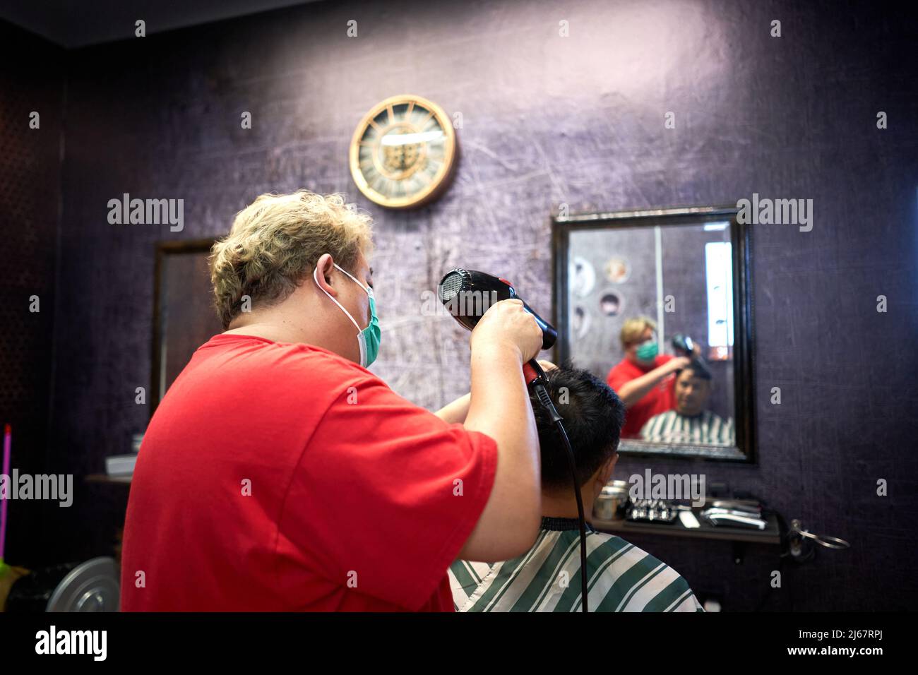 Back of a fat barber drying the hair of a client Stock Photo - Alamy