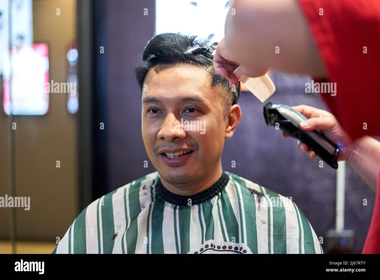 Portrait of a smiling asian man sitting on a barber shop Stock Photo ...