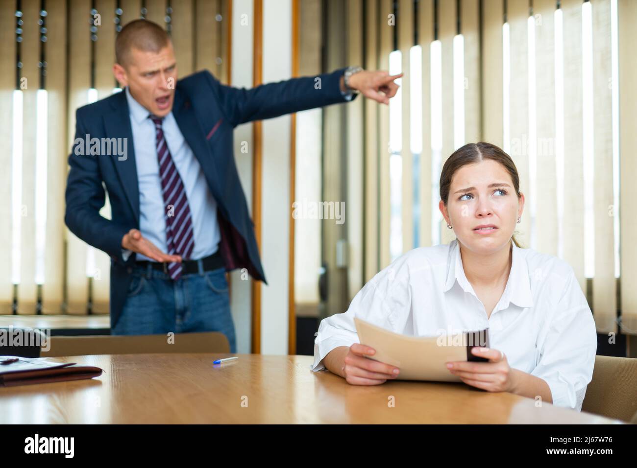 Emotional young boss berates his secretary girl in the conference room ...