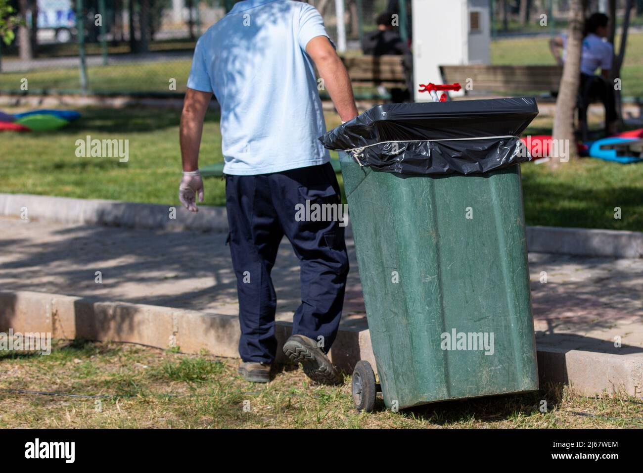 Man carrying garbage with garbage container Stock Photo - Alamy