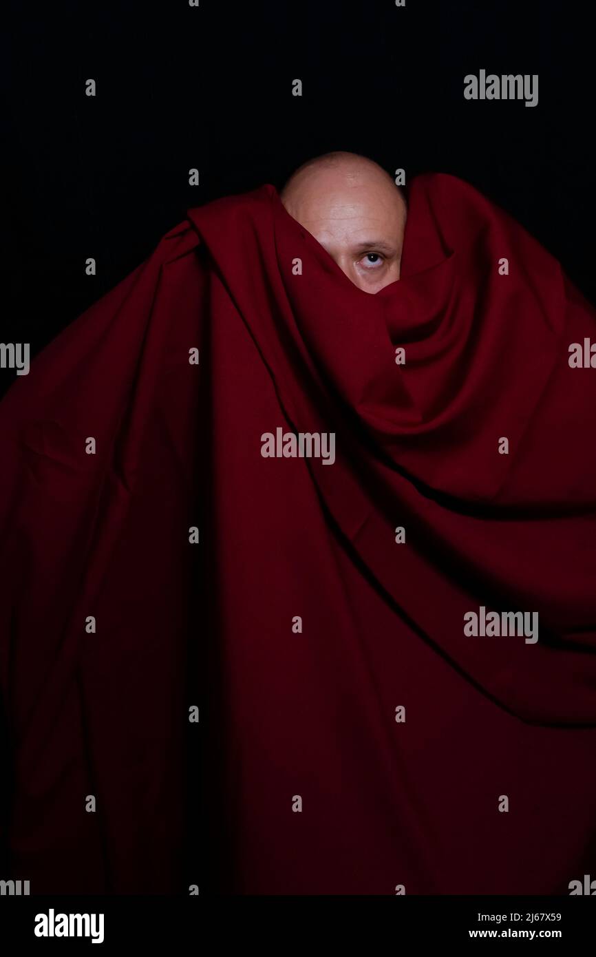 Man covered with red cloth against a black background. Salvador, Bahia ...