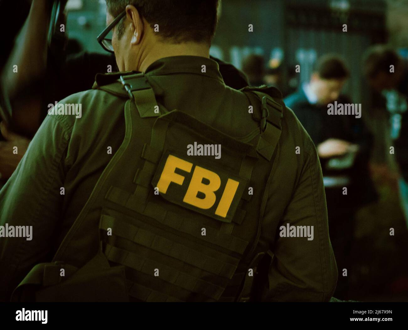 Caucasian male FBI agent wearing glasses in a green bulletproof vest ...