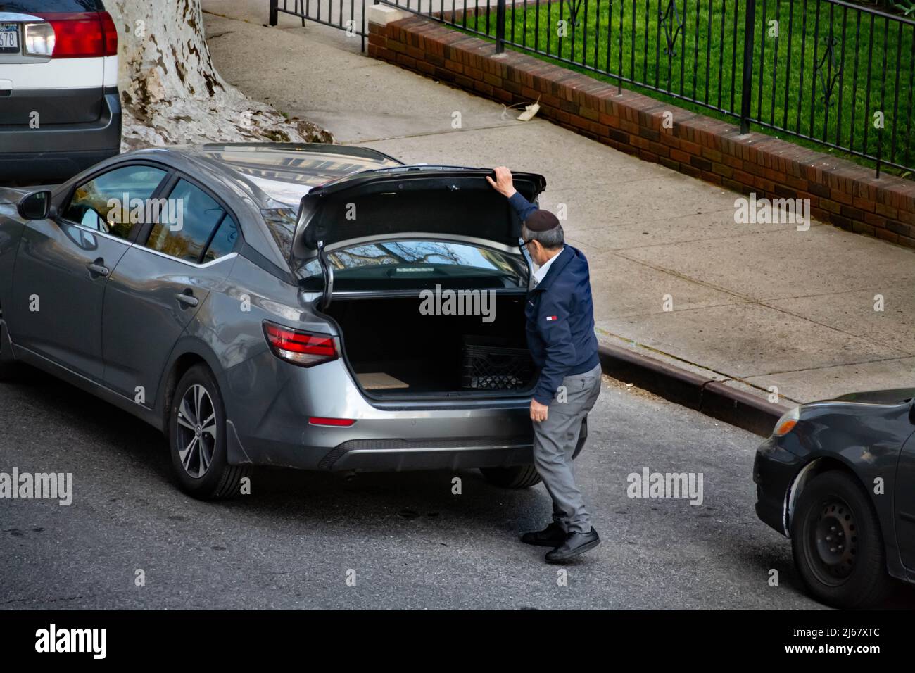 Man is opening a trunk of his car on the street Stock Photo - Alamy
