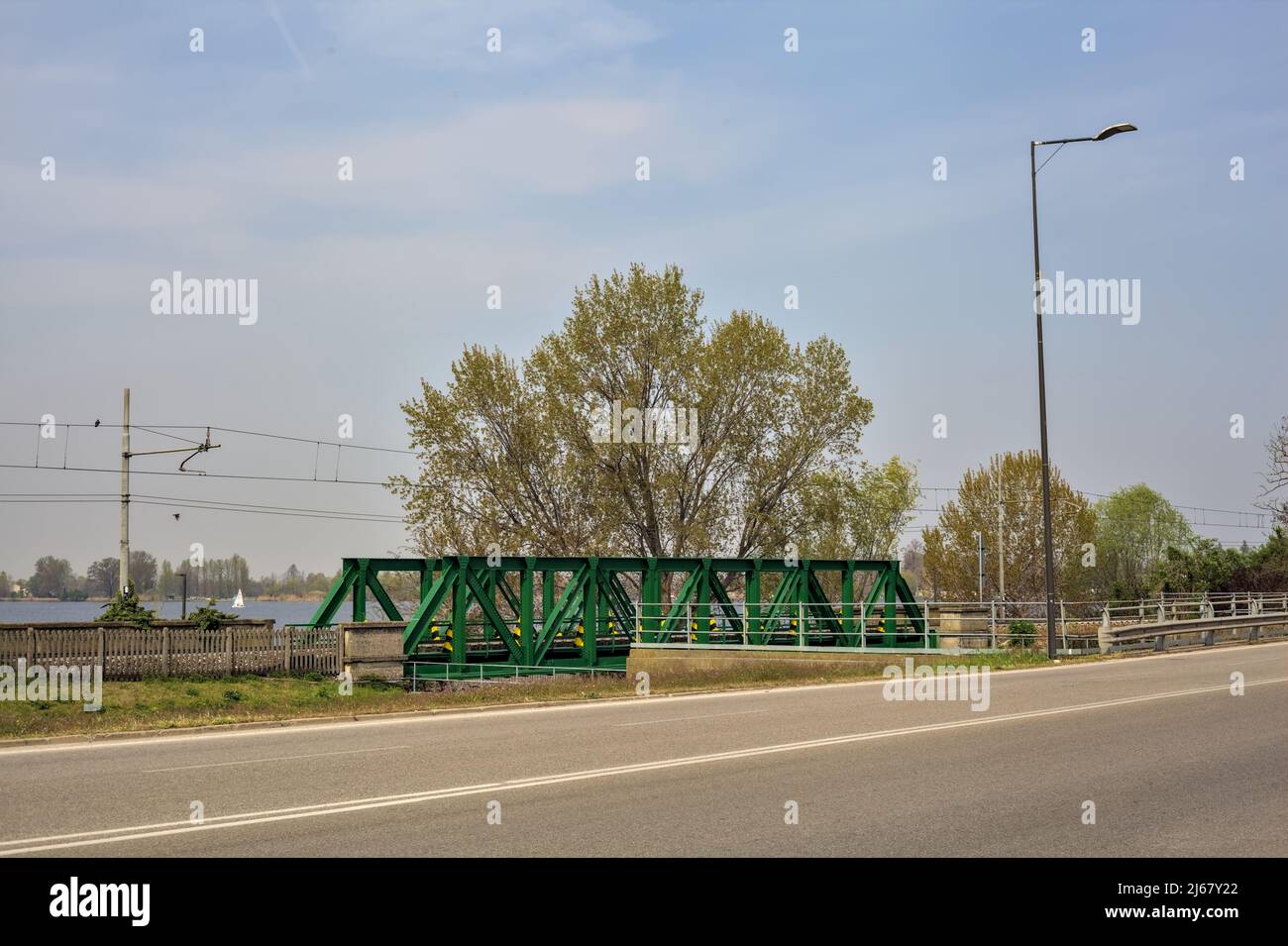 Road next to a lake and a park with railroad tracks by its edge on a ...