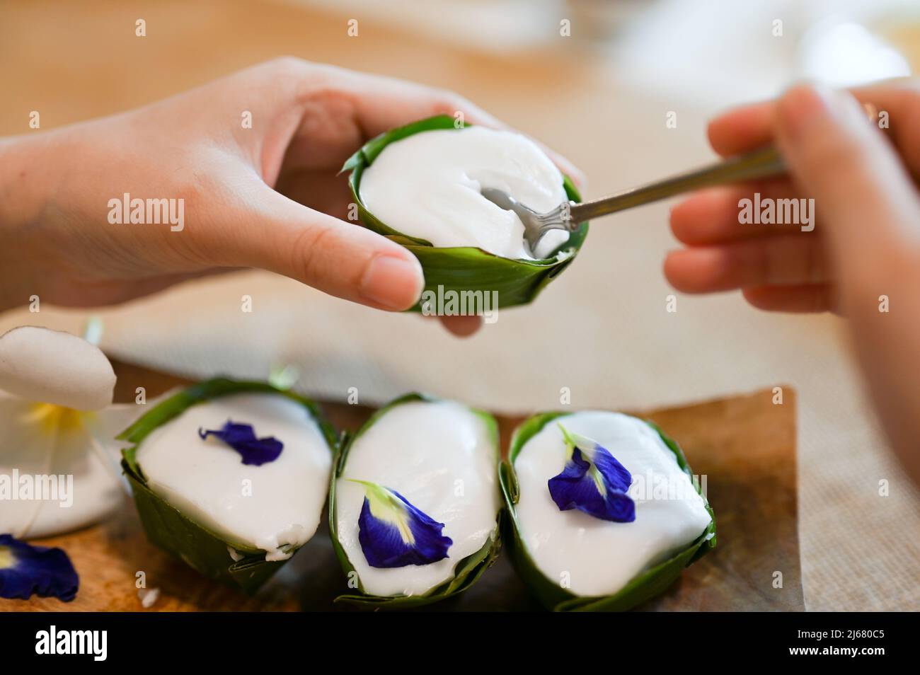 Closeup, Female eating Thai pudding topping with coconut cream sauce ...