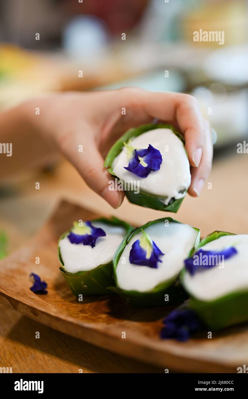 Delicious Thai pudding with coconut topping in a banana leaf cup ...