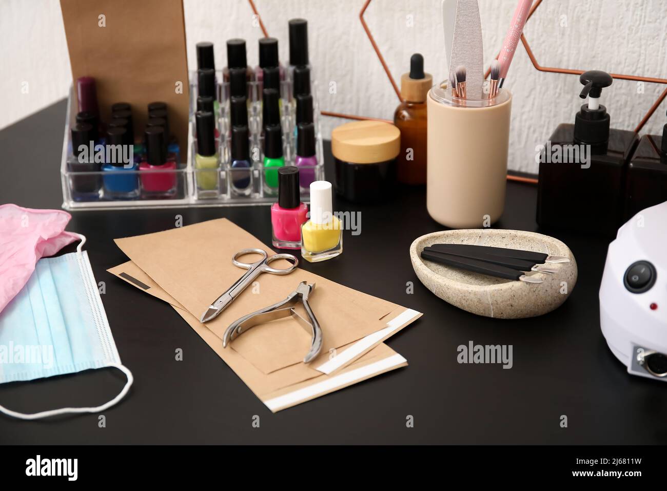 Different manicure instruments and nail polishes on table in beauty ...