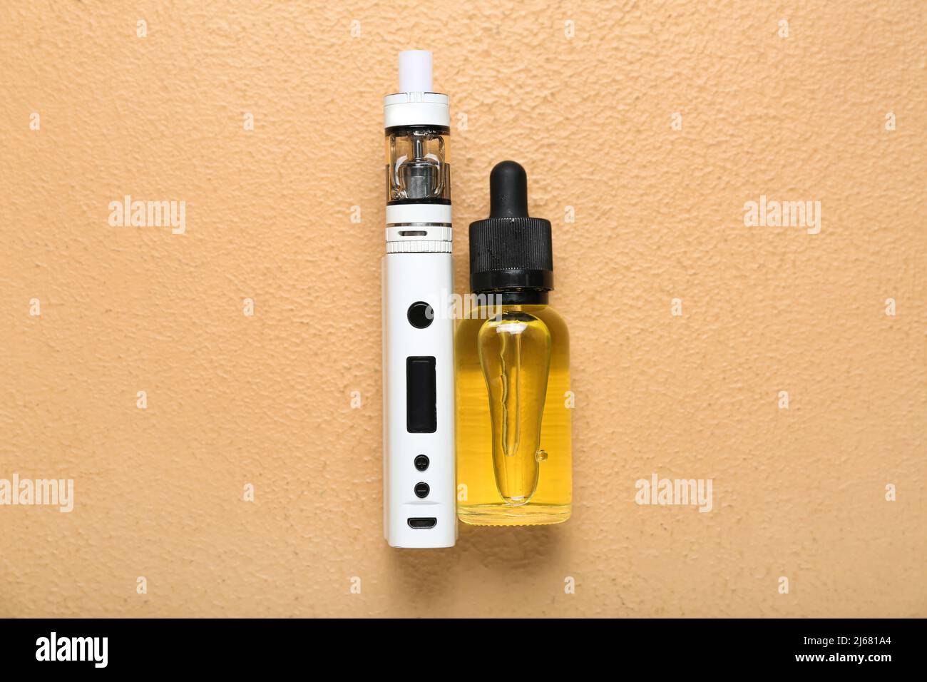 Modern vape mod and oil on beige background Stock Photo - Alamy