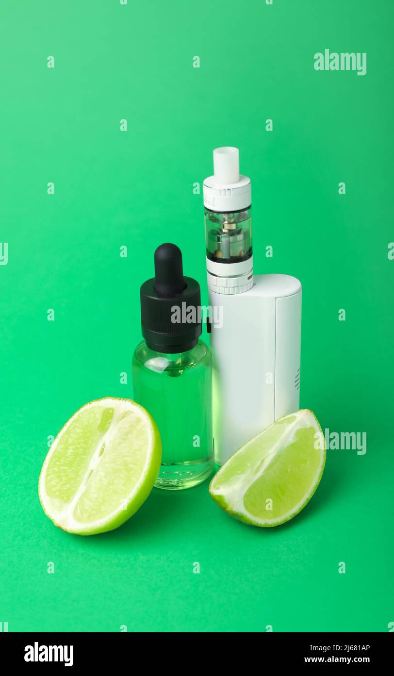 Modern vape mod, oil and lime on green background Stock Photo - Alamy