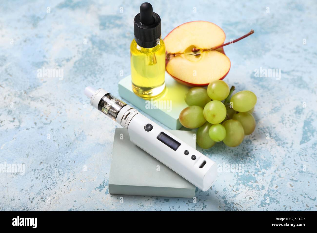 Modern vape mod, oil and fruits on blue background Stock Photo - Alamy