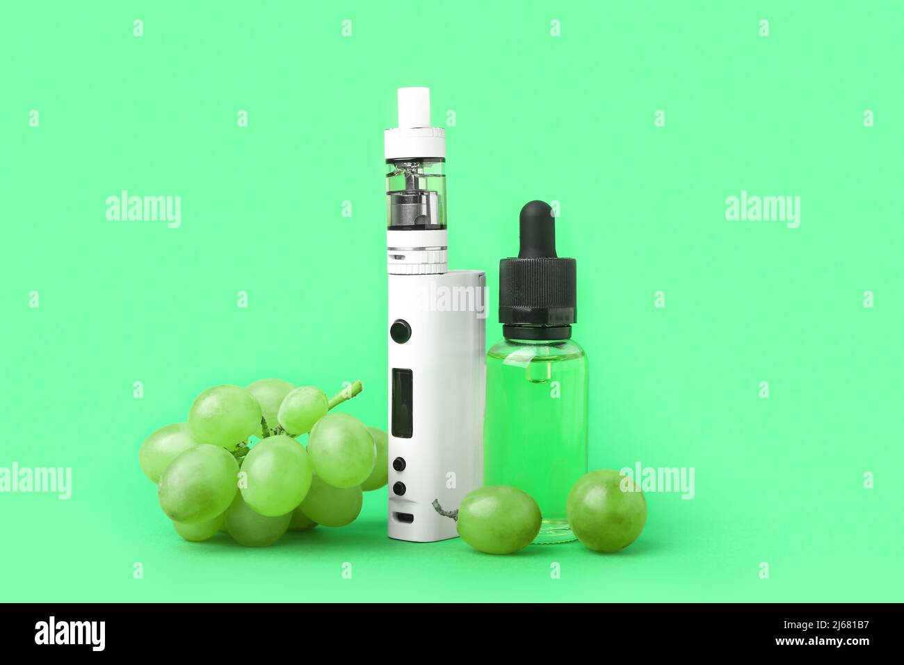 Modern vape mod, oil and grape on green background Stock Photo - Alamy