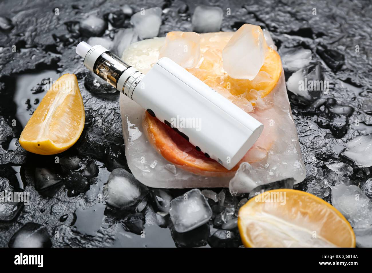Modern vape mod, orange and ice cubes on black background, closeup ...