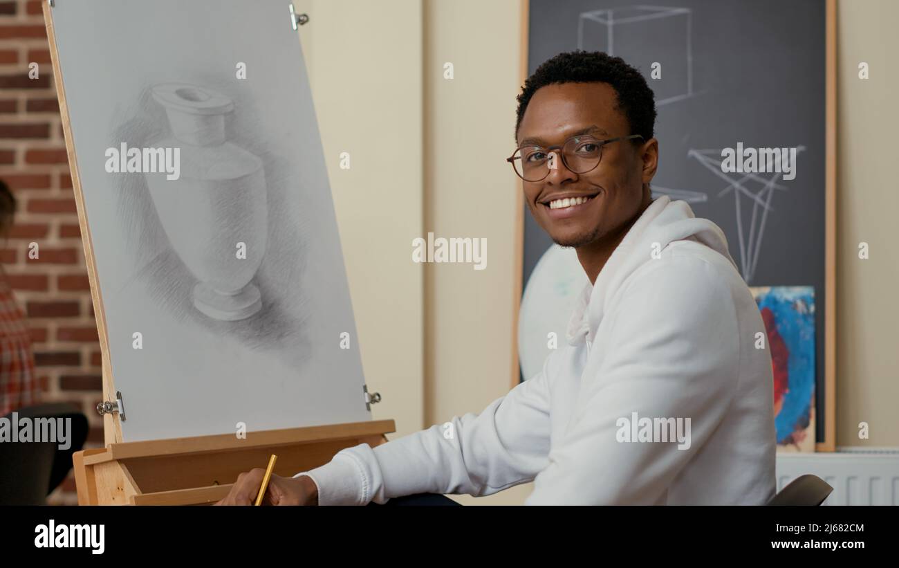 Portrait of african american man using drawing technique with pencil on ...