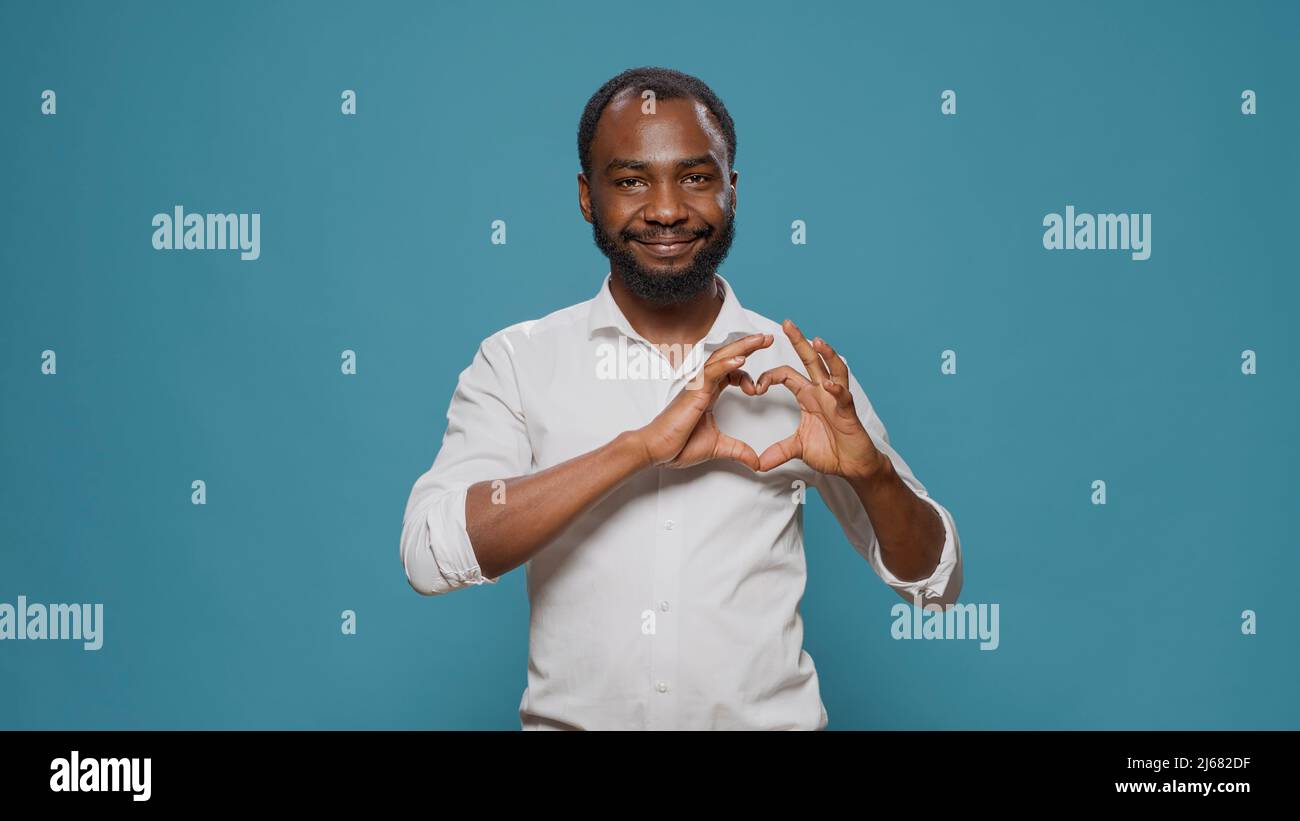 Emotional adult doing heart shape symbol with hands, advertising ...