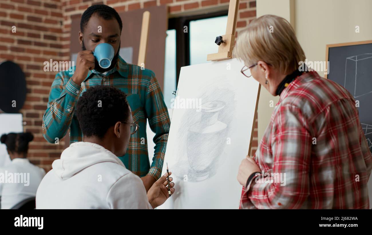 Teacher and team of students talking about vase drawing on canvas ...